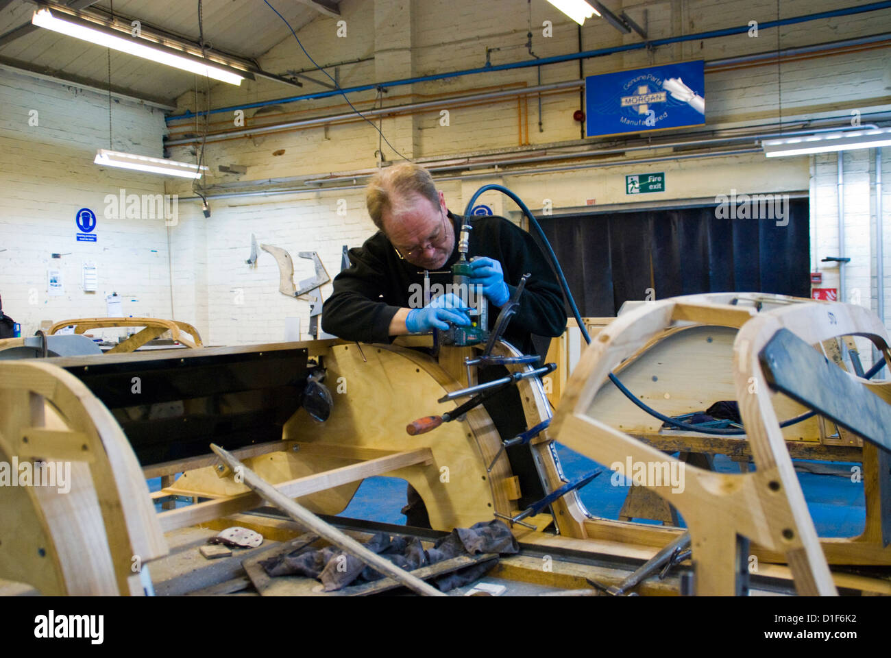 A worker building one of the hand built sports cars in the factory ...