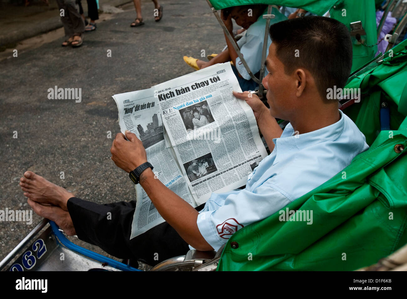 Bicycle Taxi Driver Reading a Newspaper, Hoi An, Vietnam Stock Photo ...