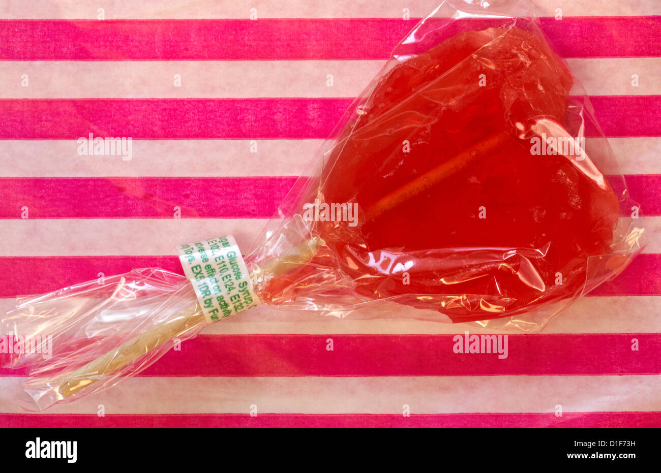 Red heart shaped lolly lollipop set on pink and white horizontally ...