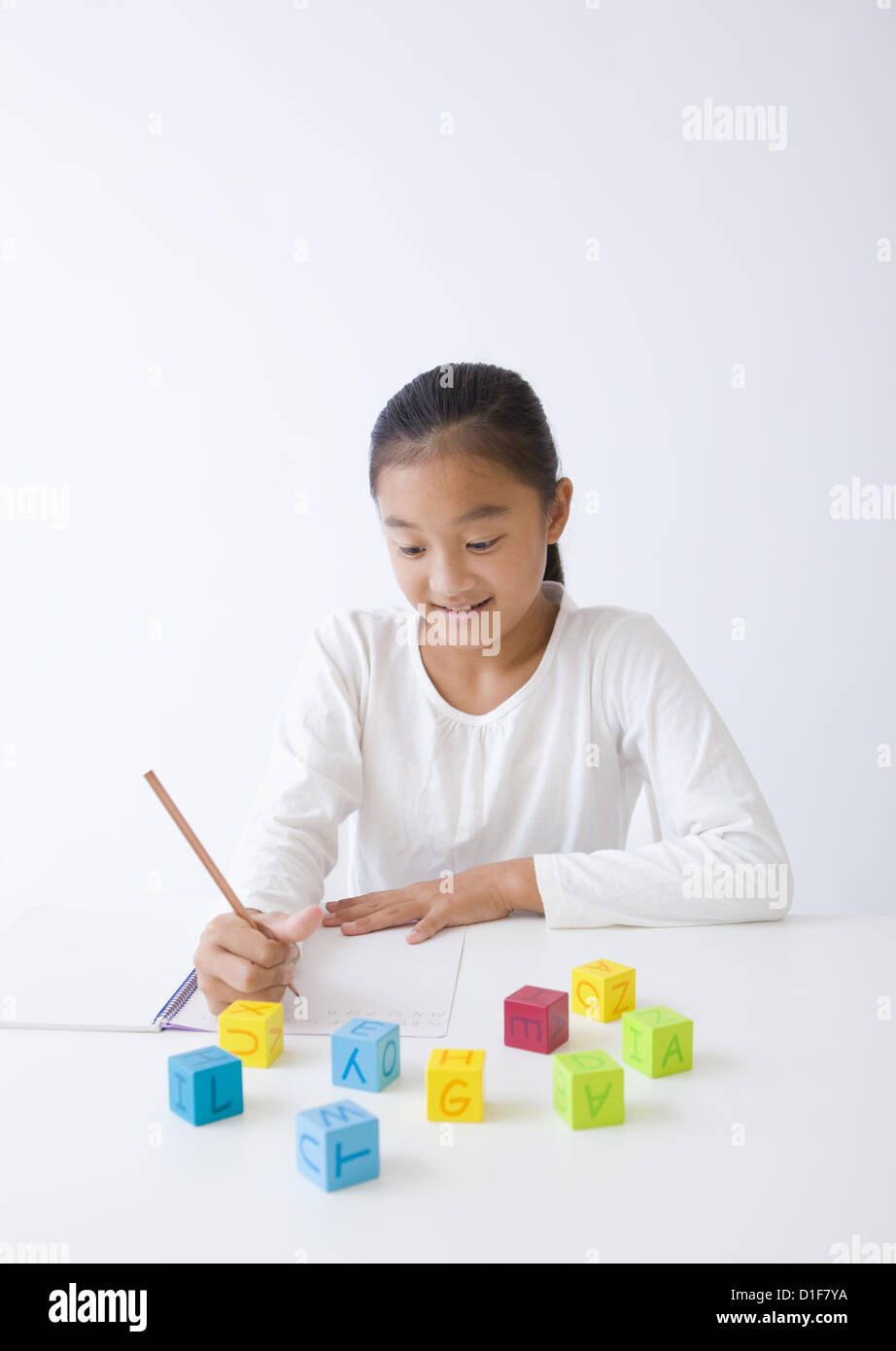 Studying girl and alphabet blocks Stock Photo - Alamy