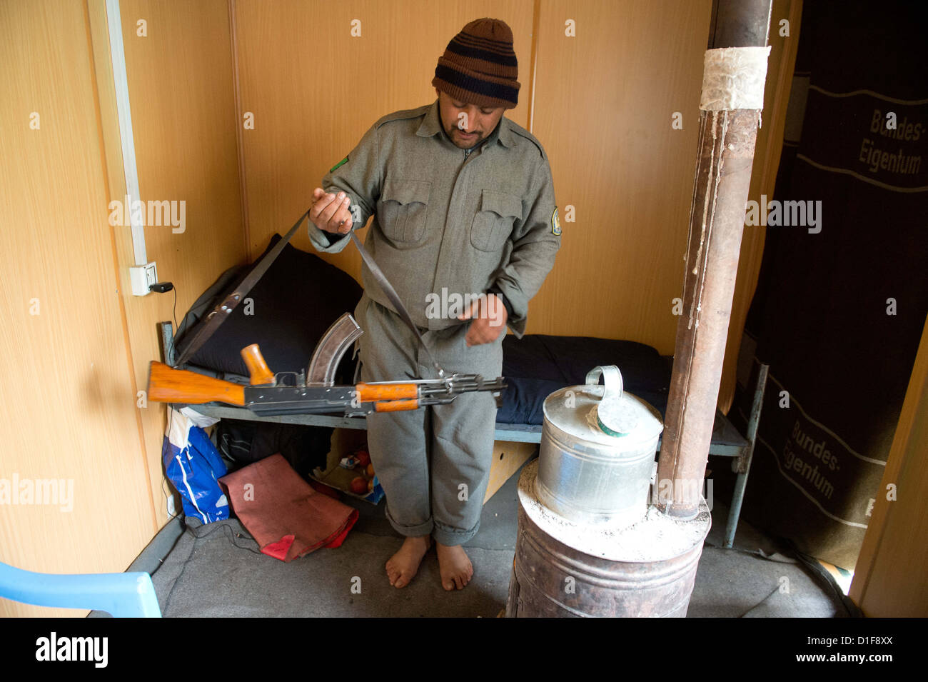 A police officer of the Afghan National Police sits in his sleeping ...