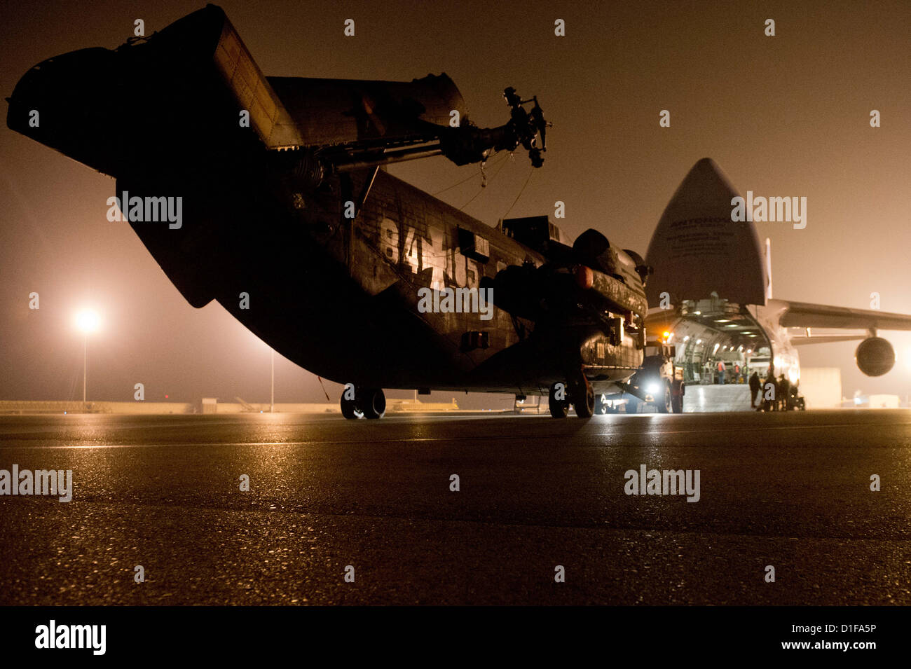 Specialists load a CH 53 helicopter into the cargo plane Antonov in the ...