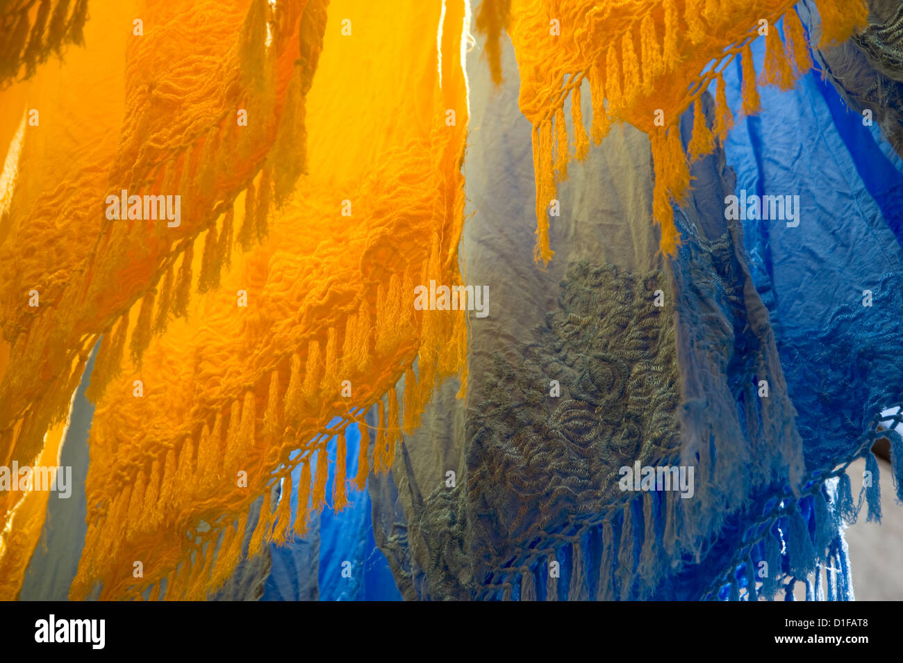 Brightly coloured dyed fabrics hanging to dry in the dyers souk ...