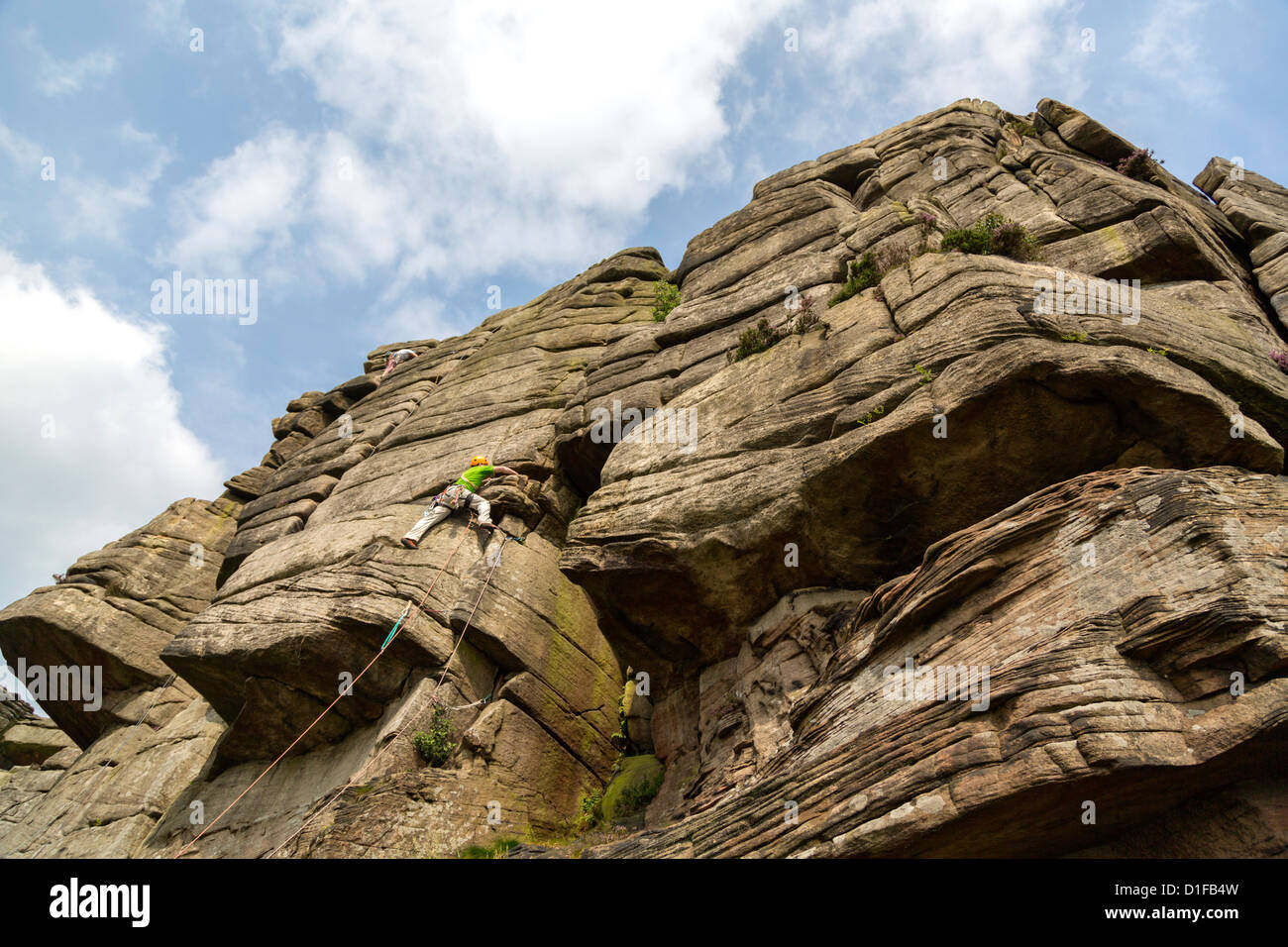 Rock climber climbing on Stanage Edge in the Peak District Derbyshire a ...