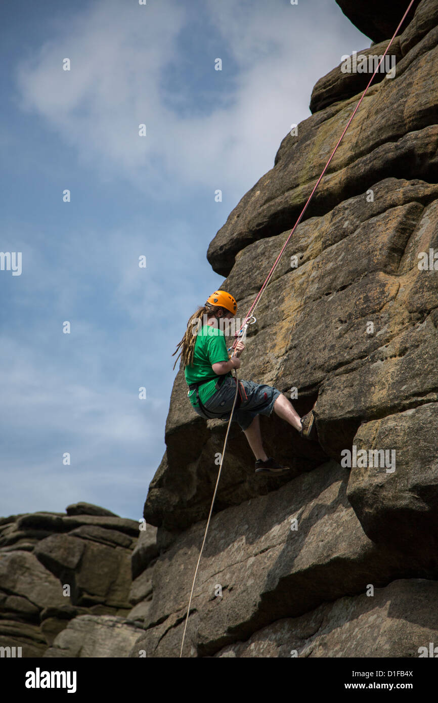 Rock climber climbing on Stanage Edge in the Peak District Derbyshire a ...