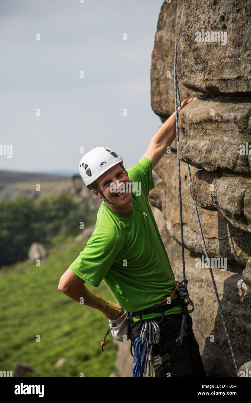 Rock climber climbing on Stanage Edge in the Peak District Derbyshire a ...