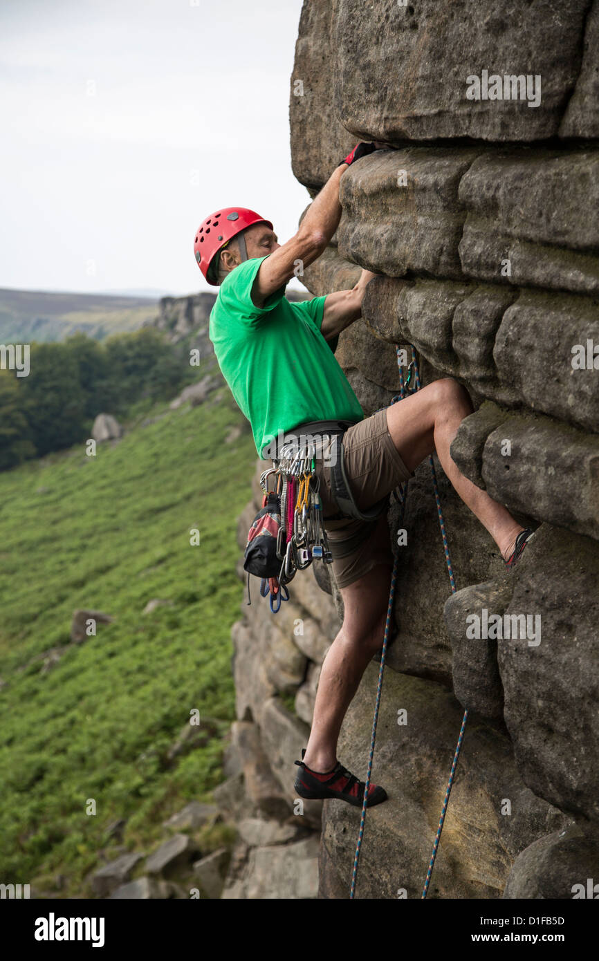 Rock climber climbing on Stanage Edge in the Peak District Derbyshire a ...