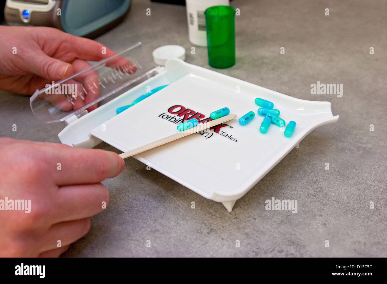 Pharmacist counts pill capsules on pill counting tray Stock Photo - Alamy