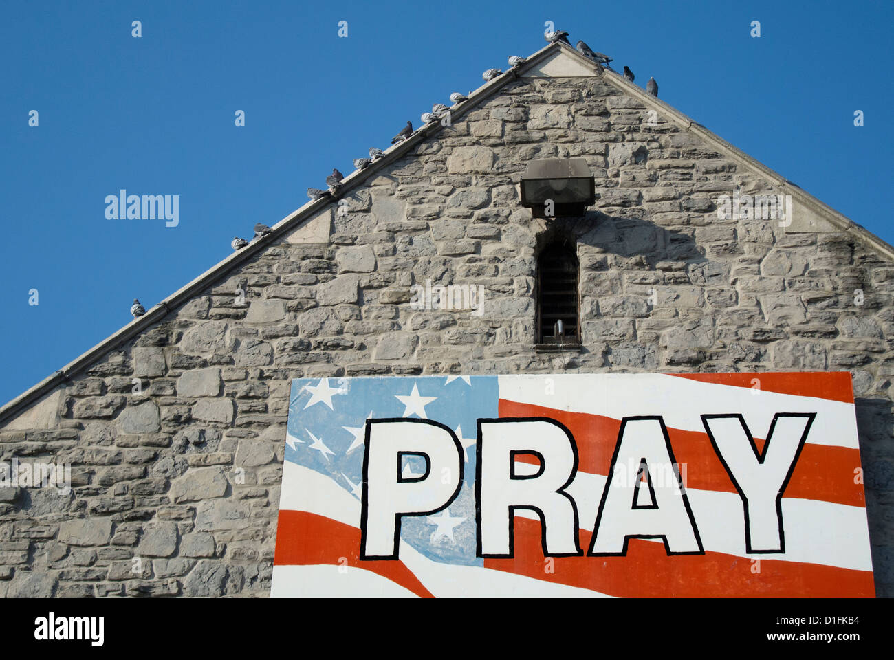 Pray banner on side of church Stock Photo - Alamy