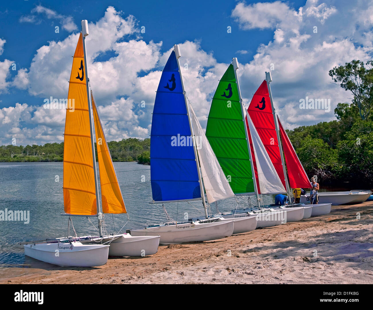 Sailing boats with colourful sails on beach beside river estuary in ...