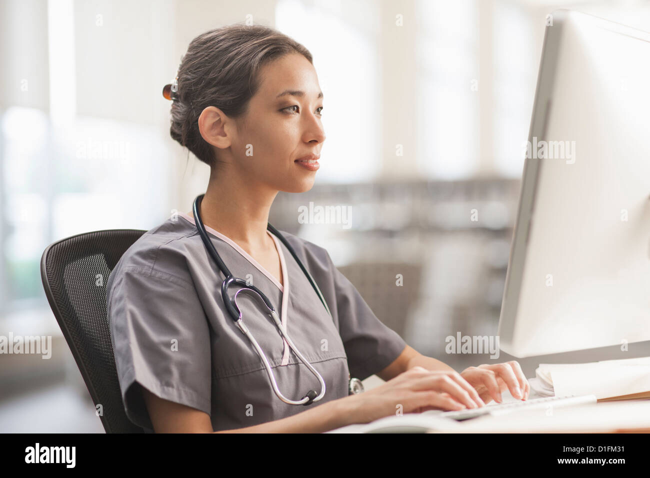 Mixed race nurse using computer Stock Photo - Alamy