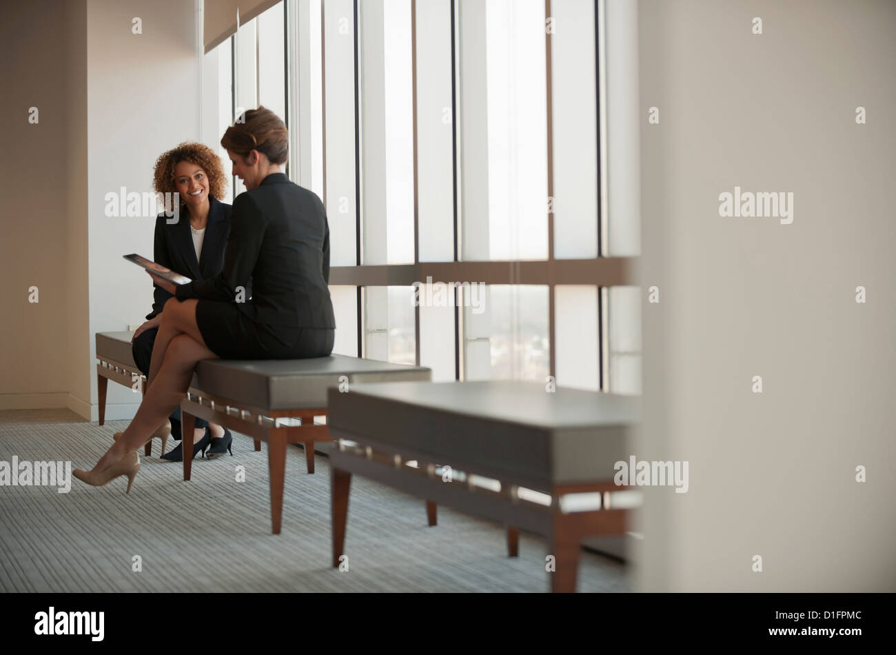 Businesswomen talking in waiting area Stock Photo - Alamy