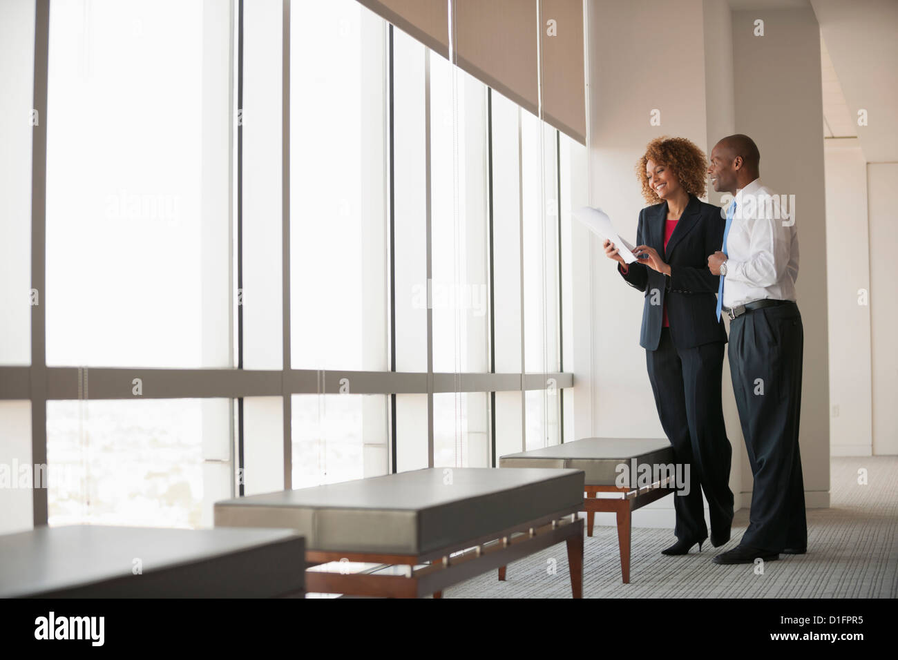Business people talking together near window Stock Photo - Alamy