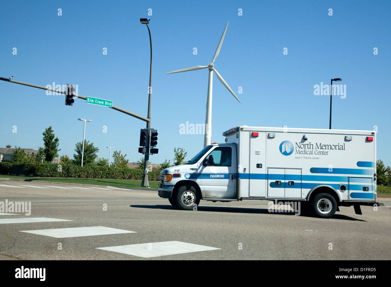 A paramedic truck and a modern sight of wind turbine on street corner ...
