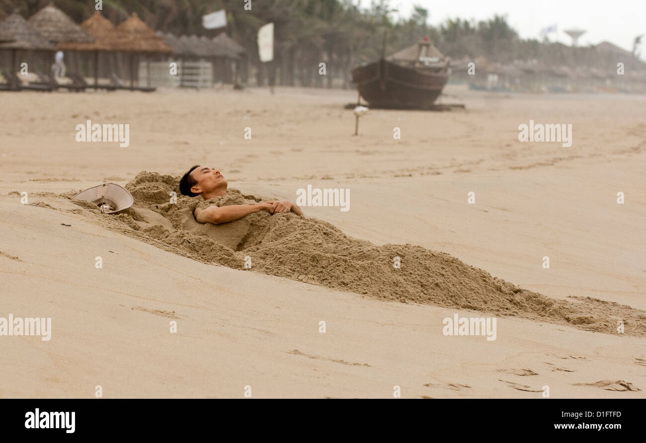 Man lying in the sand covered hi-res stock photography and images - Alamy