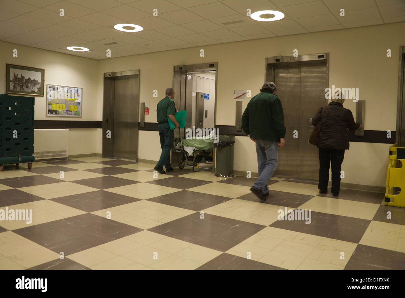 Ambulance man taking NHS stretcher patient into lift of Hospital two ...