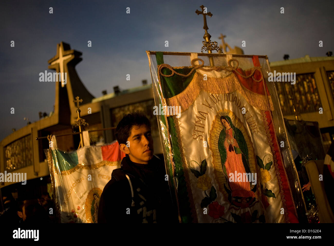 A pilgrim carries a banner with the image of the Our Lady of Guadalupe ...
