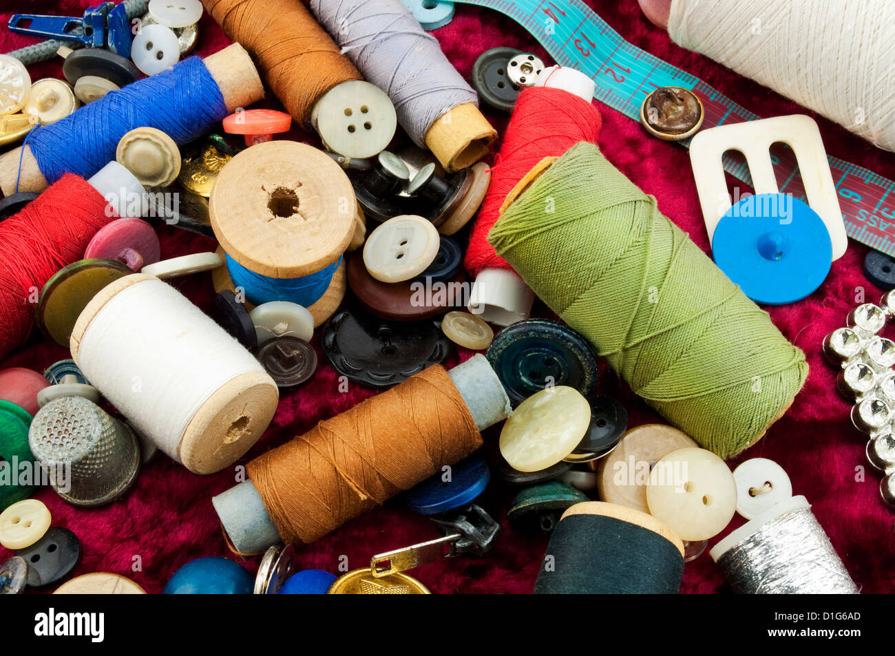 buttons and spools of thread on cloth red background Stock Photo - Alamy