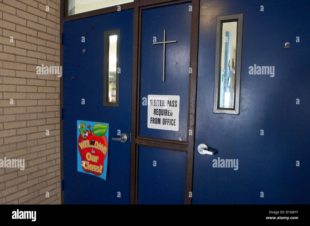 School door with cross and sign indicating the need for visitor pass ...