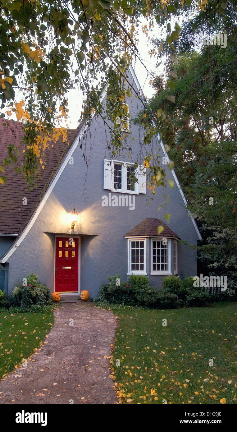 Exterior gray cottage style house with pointed roof and red door at ...