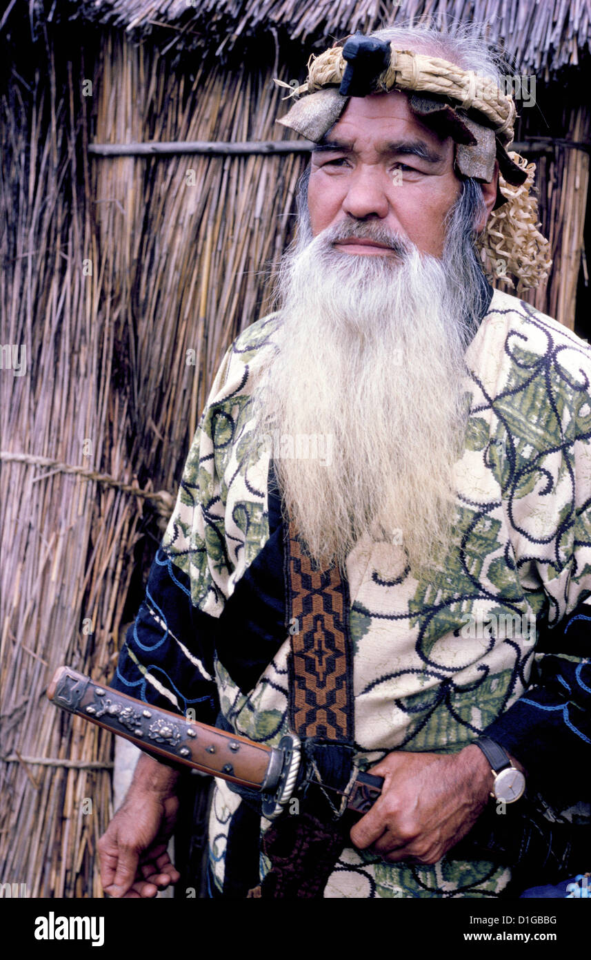 A bearded Ainu man in traditional dress and wearing a wood-fiber Stock ...