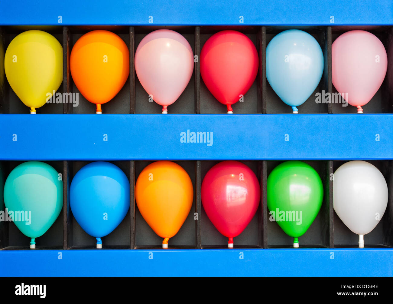 A blue wall case with colorful balloons. Photo is of a boardwalk arcade ...