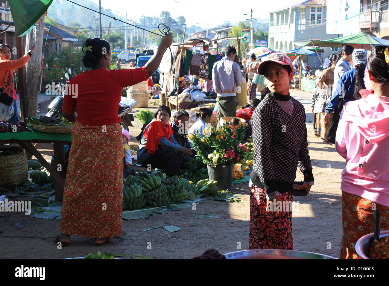 People meander through a busy street on market day in the village of ...