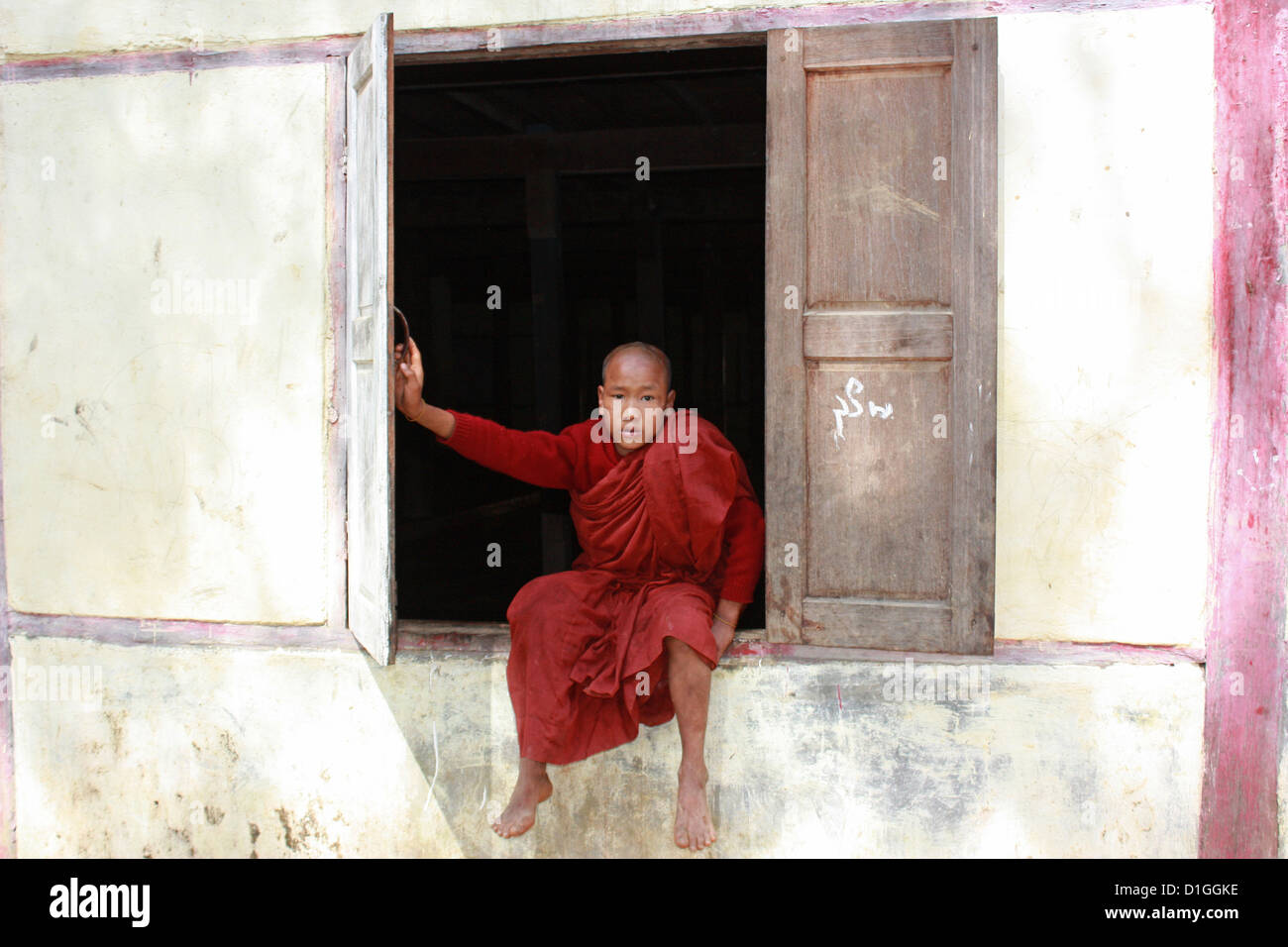 A monk sits in a window of a monastery in a rural area inhabited by the ...