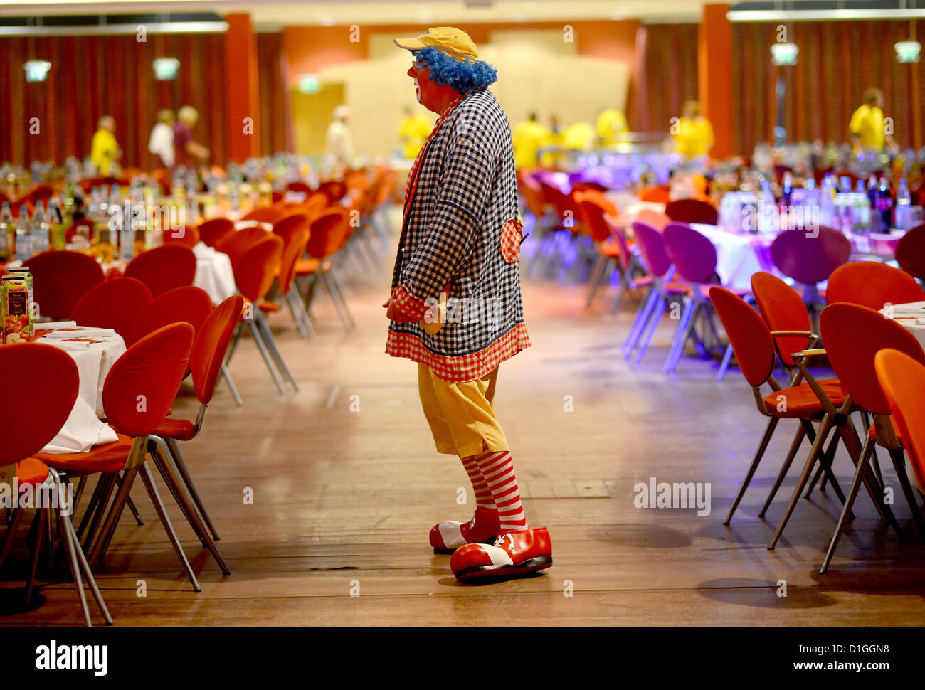 A man dressed as a clown walks through the hall at the traditional ...