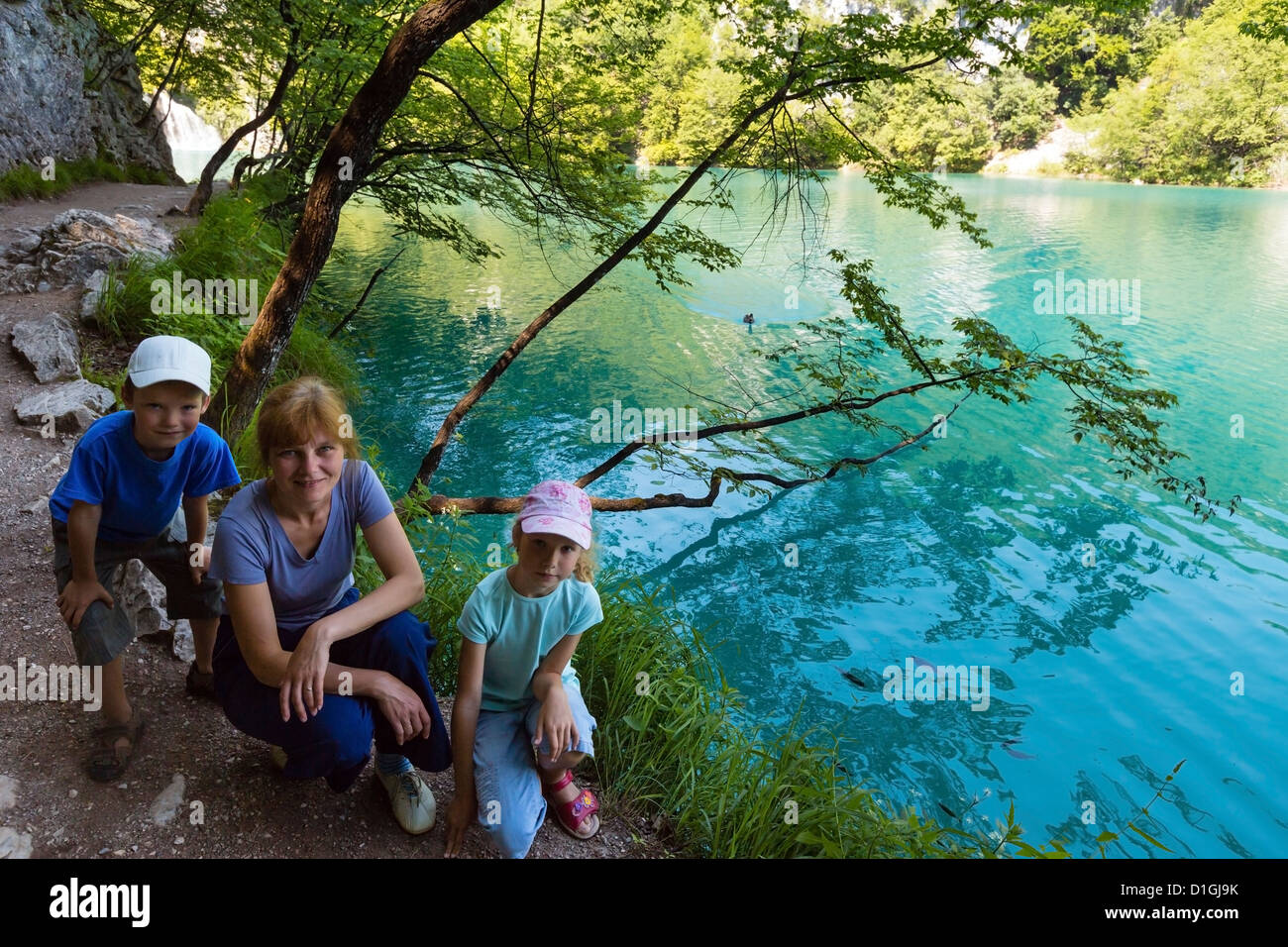 Family near summer azure limpid transparent lake (Plitvice Lakes ...