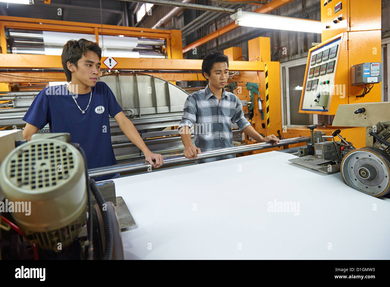 Young textile factory workers inspecting newly pressed fabric Stock ...