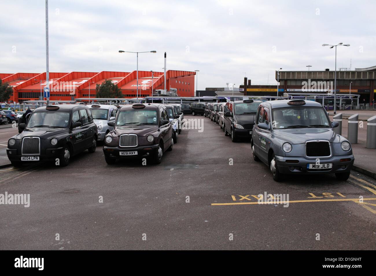 Taxis line up in ranks outside the airport terminal awaiting the ...