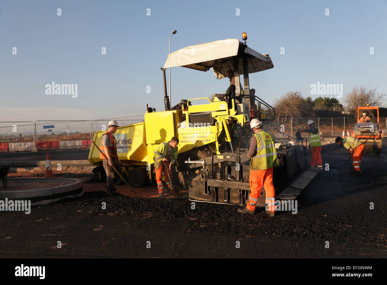 A Civil Engineering contractor highway maintenance gang laying asphalt ...