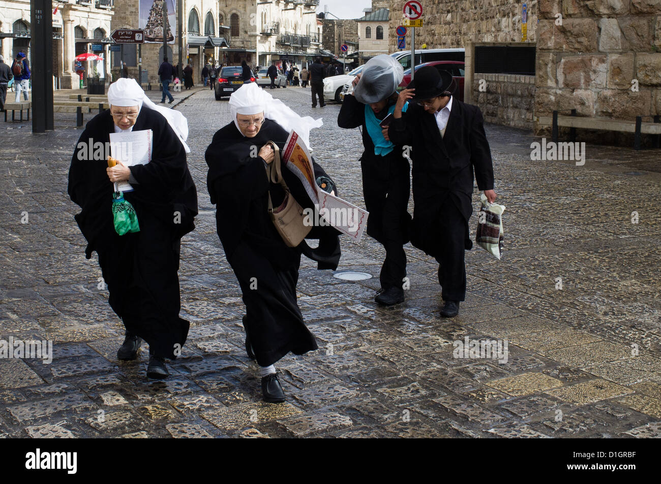 Two Christian nuns and two Jewish Orthodox men lean forward against the ...