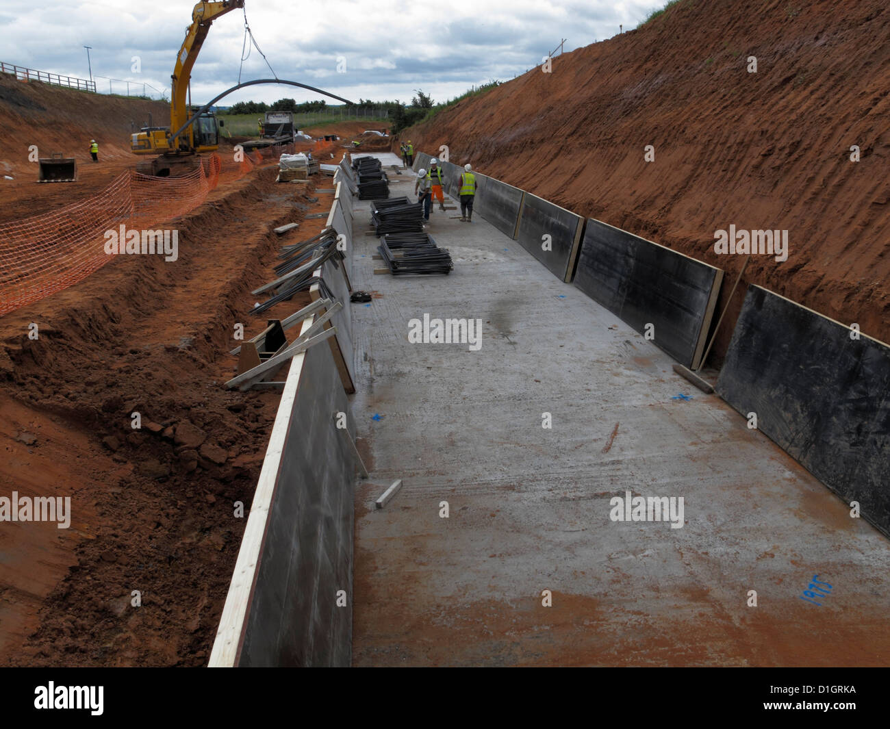 tracked excavator craning in lengths of steel reinforcing bar bars ...