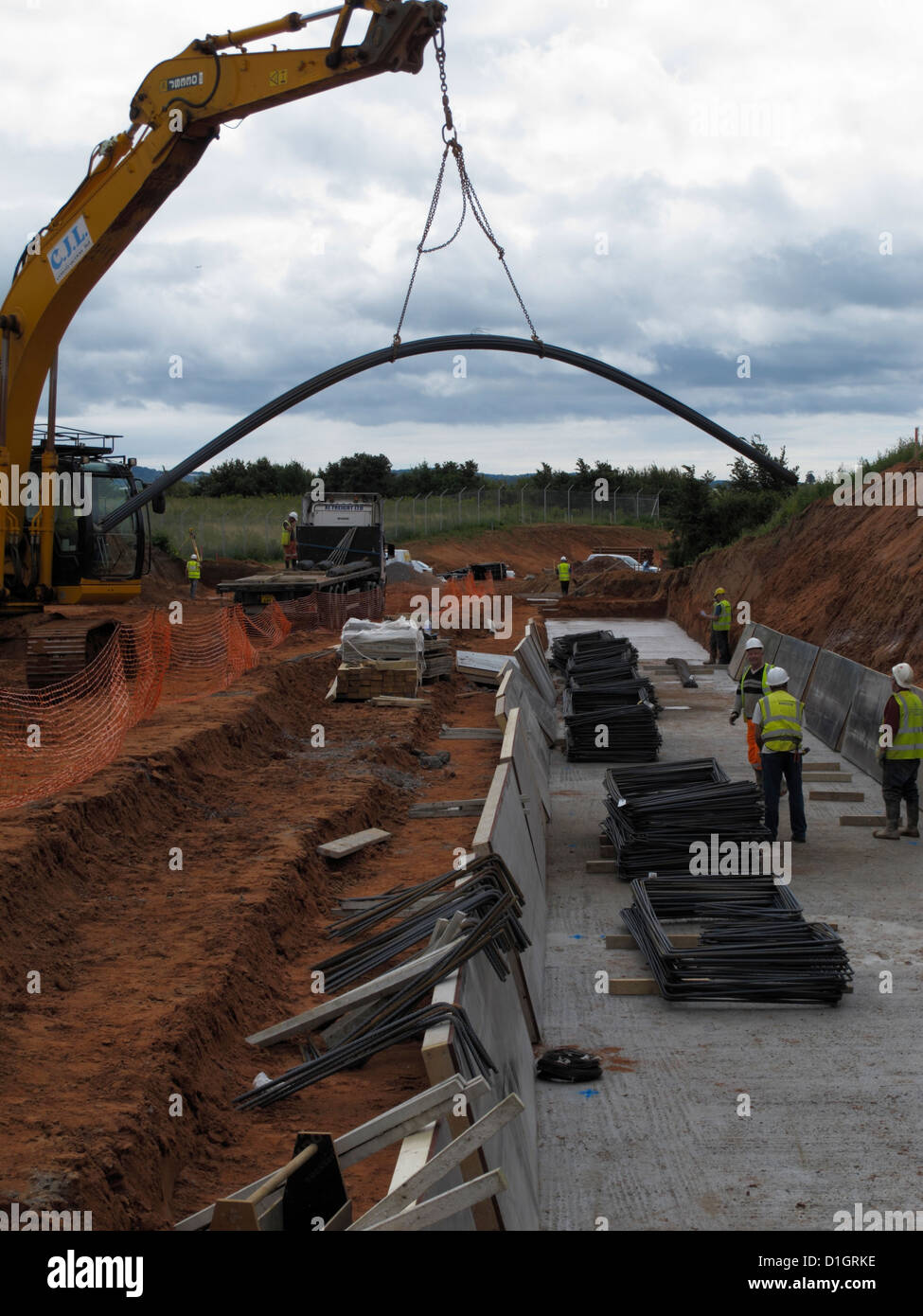 tracked excavator craning in lengths of steel reinforcing bar bars ...