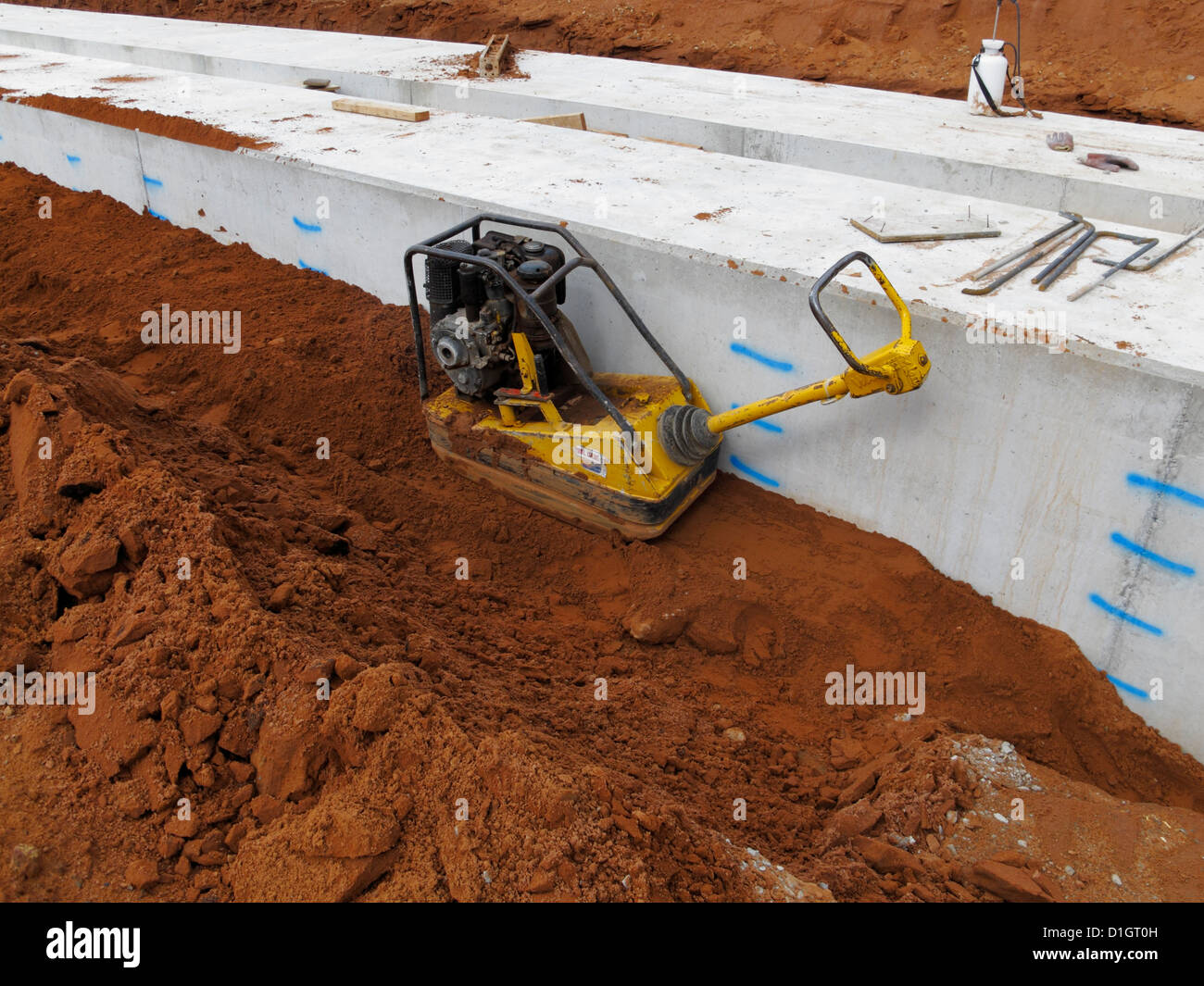 vibrating plate compacter backfilling beside a strip foundation of ...