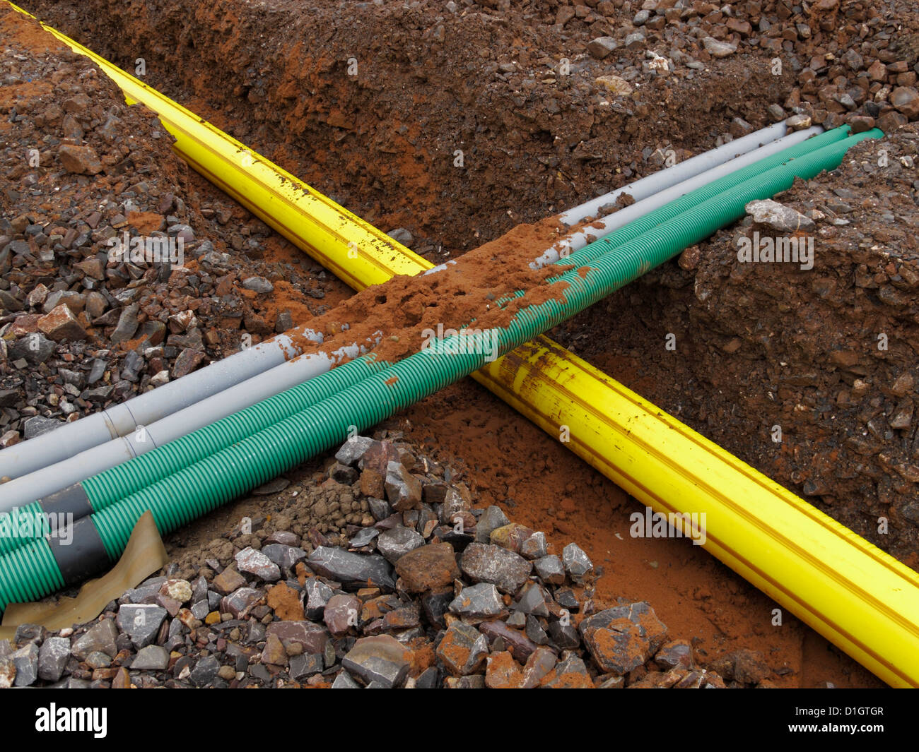 New yellow high pressure gas main in a trench crossed by grey and green ... New yellow high pressure gas main in a trench crossed by grey and green ...