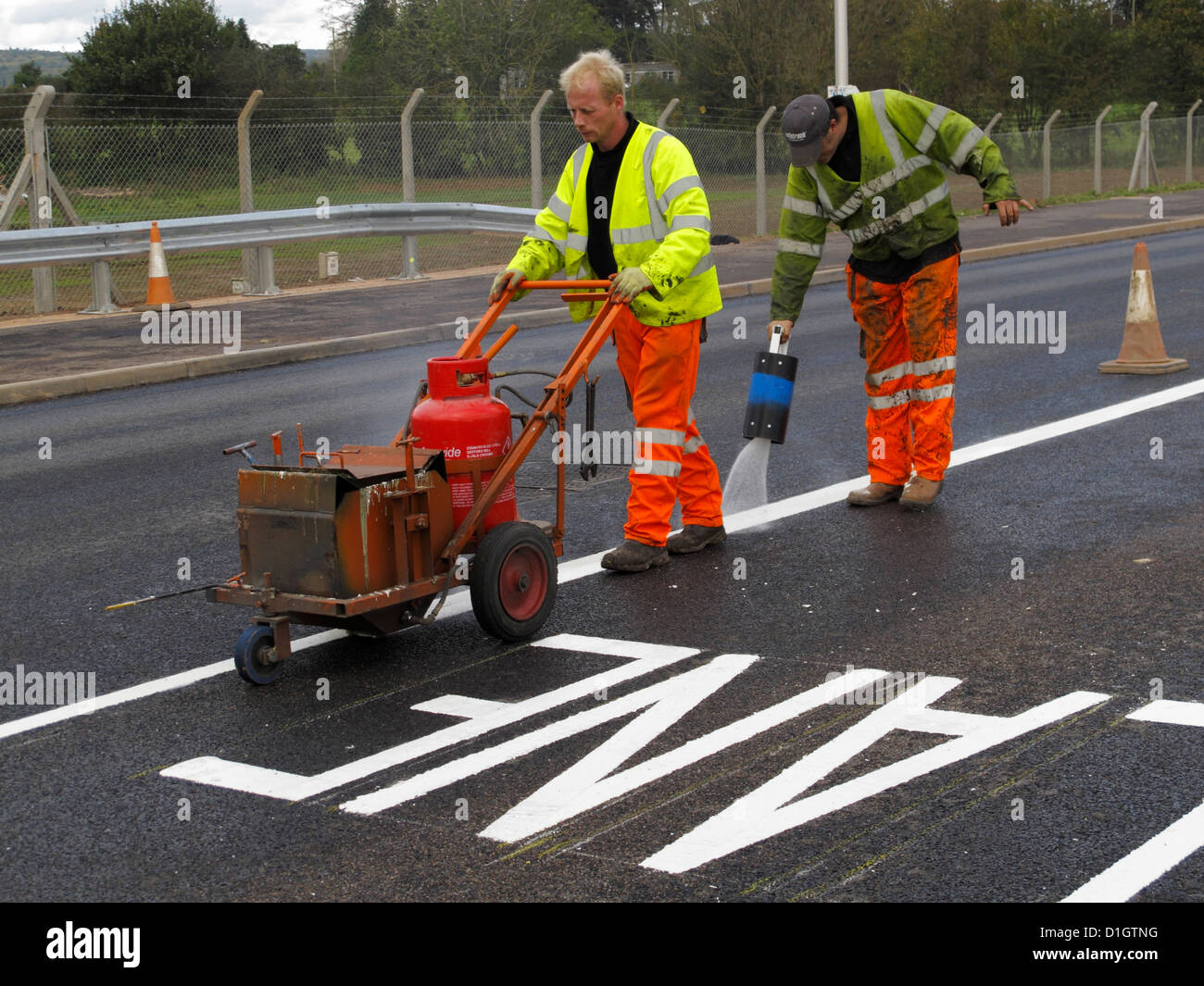 Road marking lining gang screeding white lines on a highway UK using ...