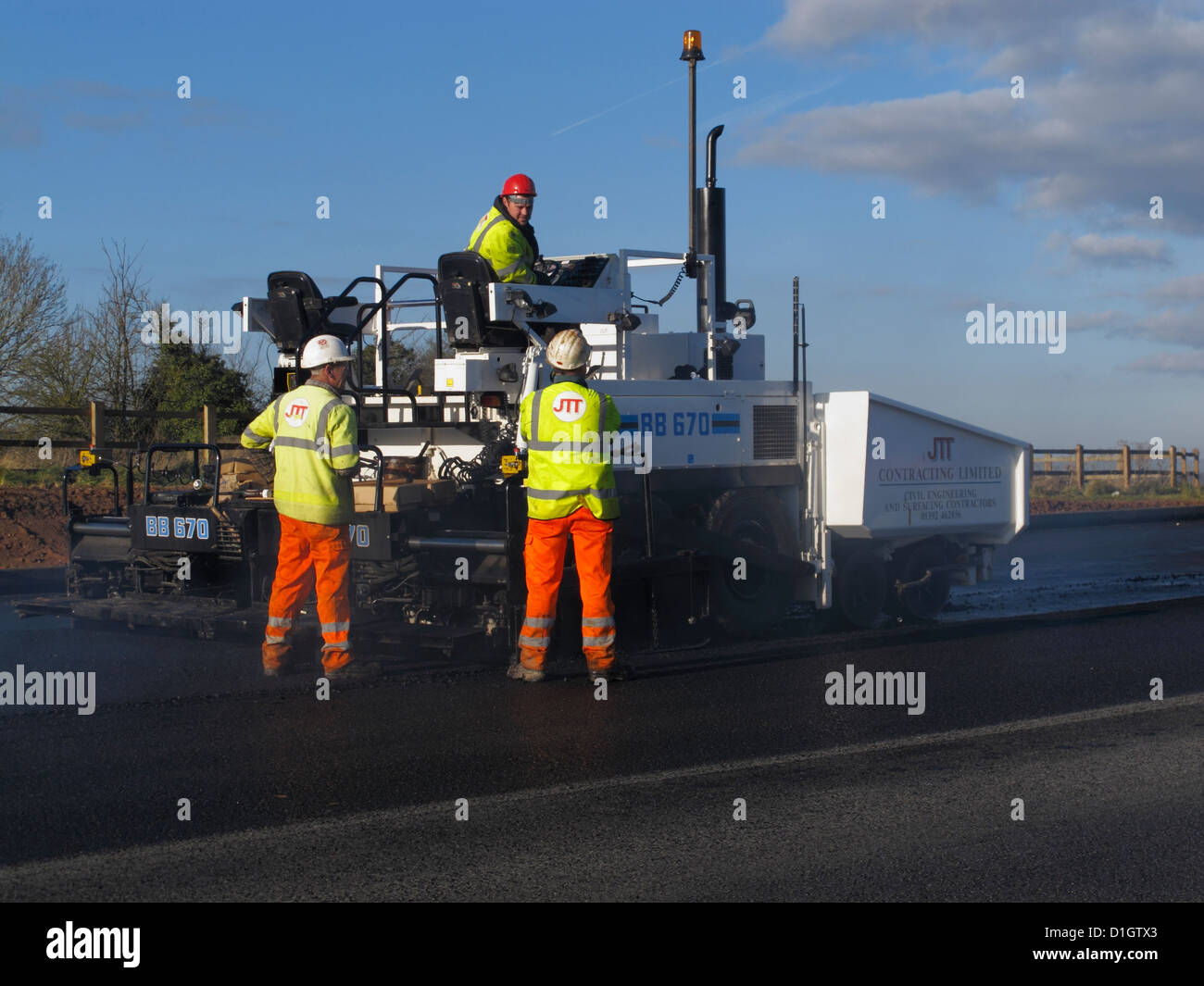 A Civil Engineering contractor highway maintenance gang laying asphalt ...