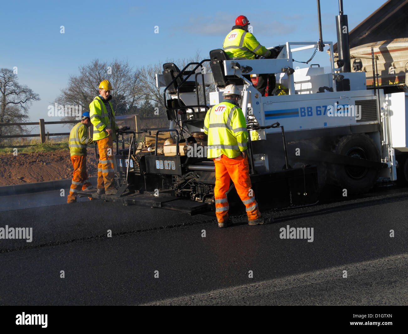 A Civil Engineering contractor highway maintenance gang laying asphalt ...