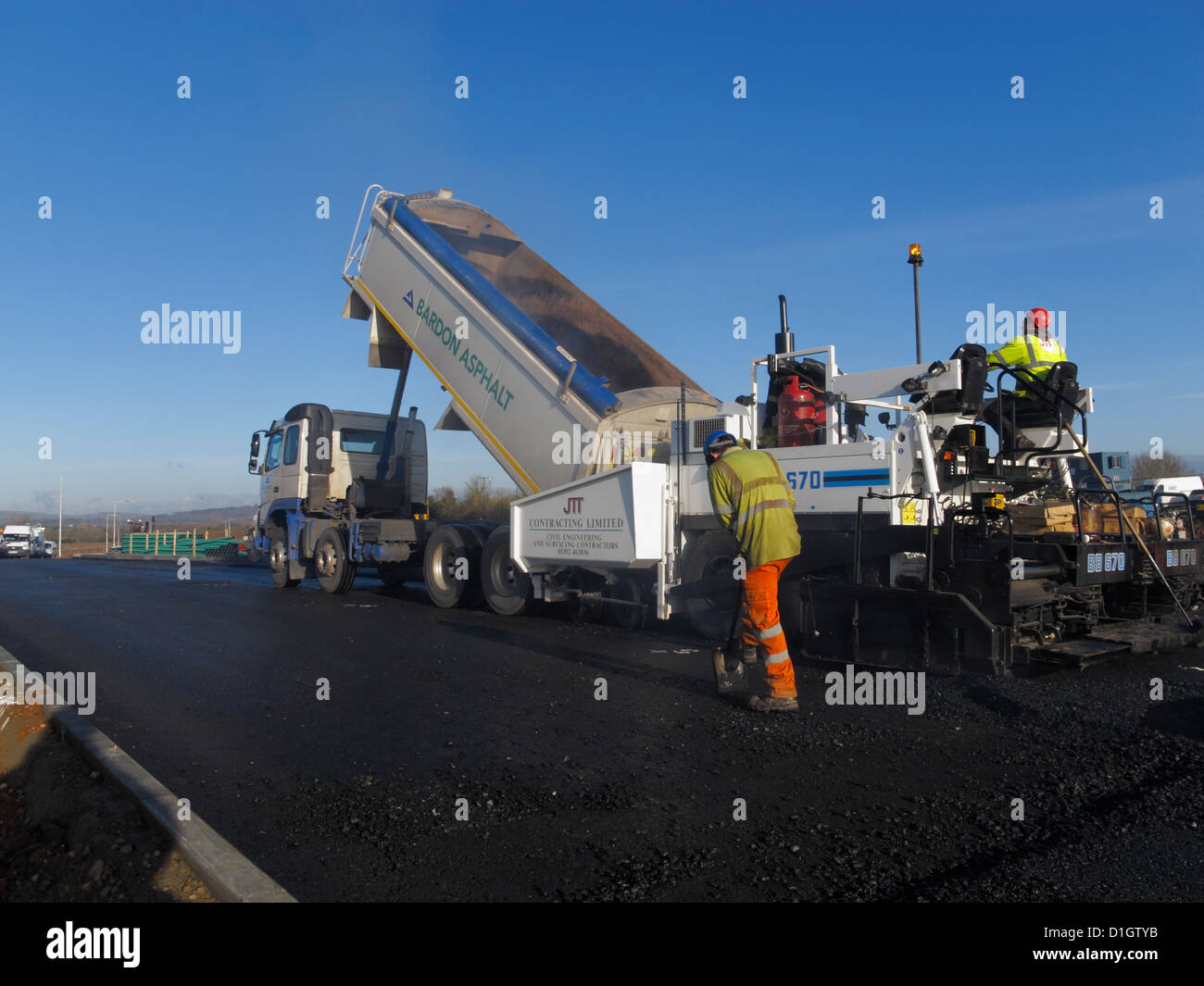 A Civil Engineering contractor highway maintenance gang laying asphalt ...