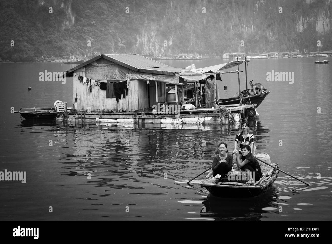 Women in a wooden boat with their floating wooden home in the ...