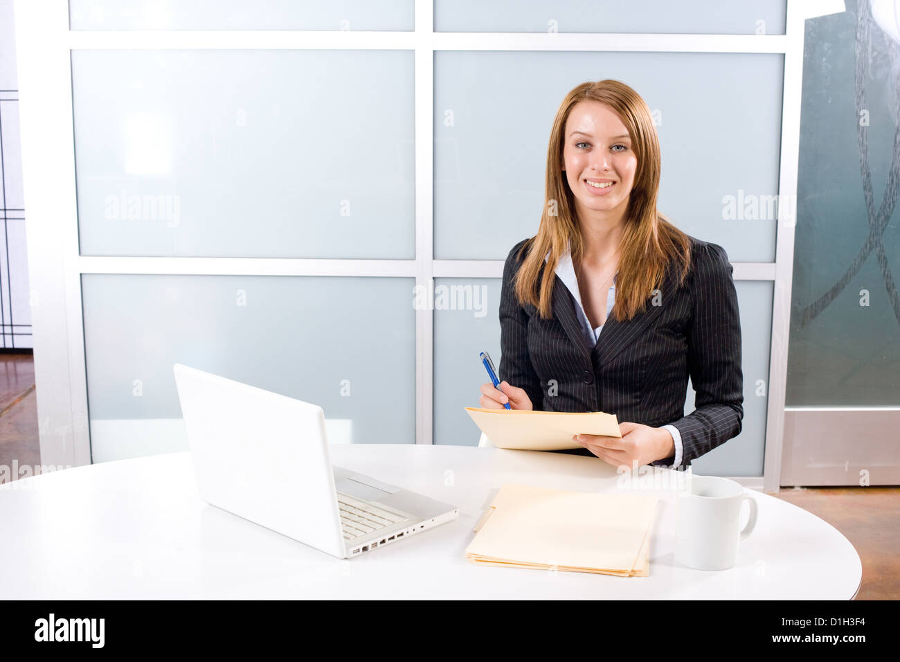 Business Woman Writing notes at desk in a modern office Stock Photo - Alamy