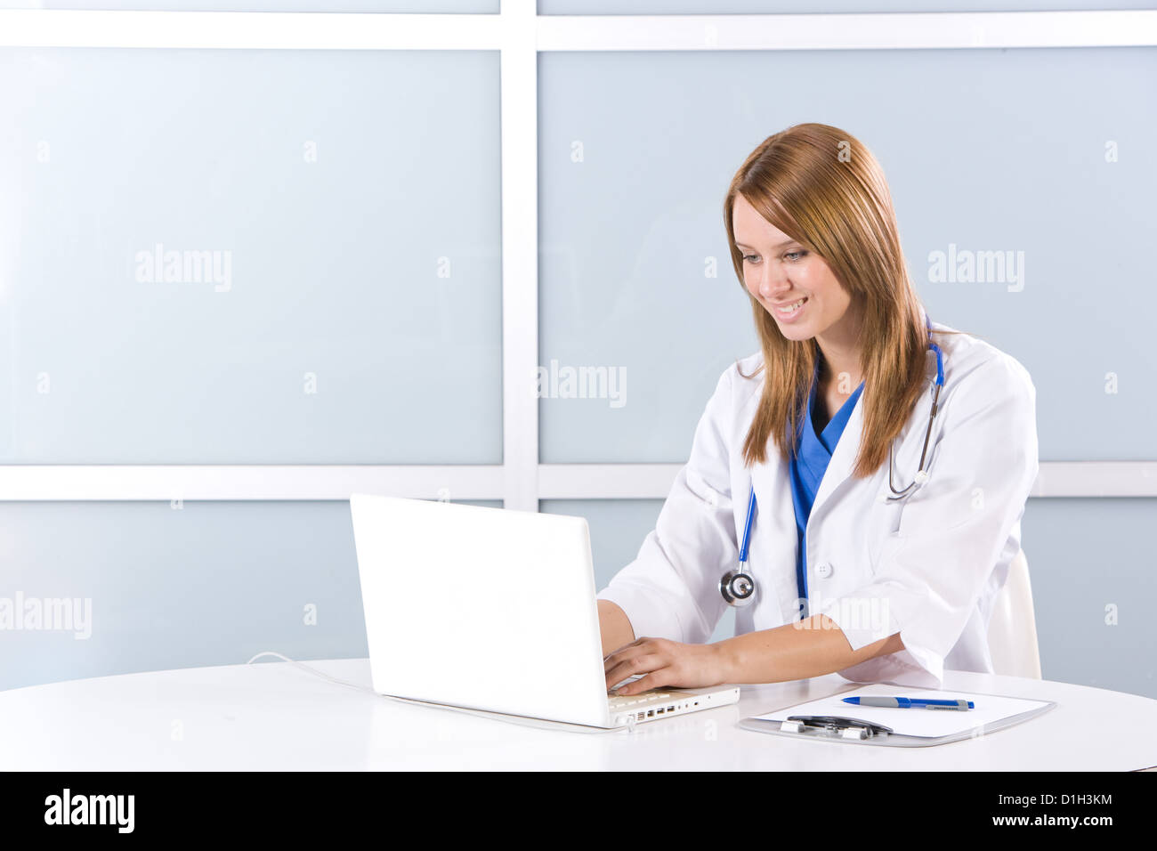 Female doctor on computer at desk in a modern hospital Stock Photo - Alamy