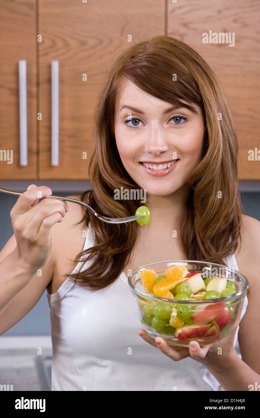 Woman Eating a Bowl of Fresh Fruit in a Modern Kitchen Stock Photo - Alamy