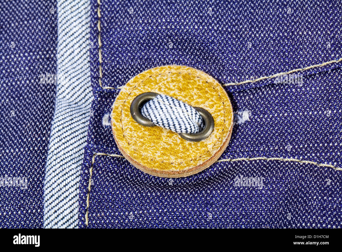 Yellow button on jeans texture close view Stock Photo - Alamy