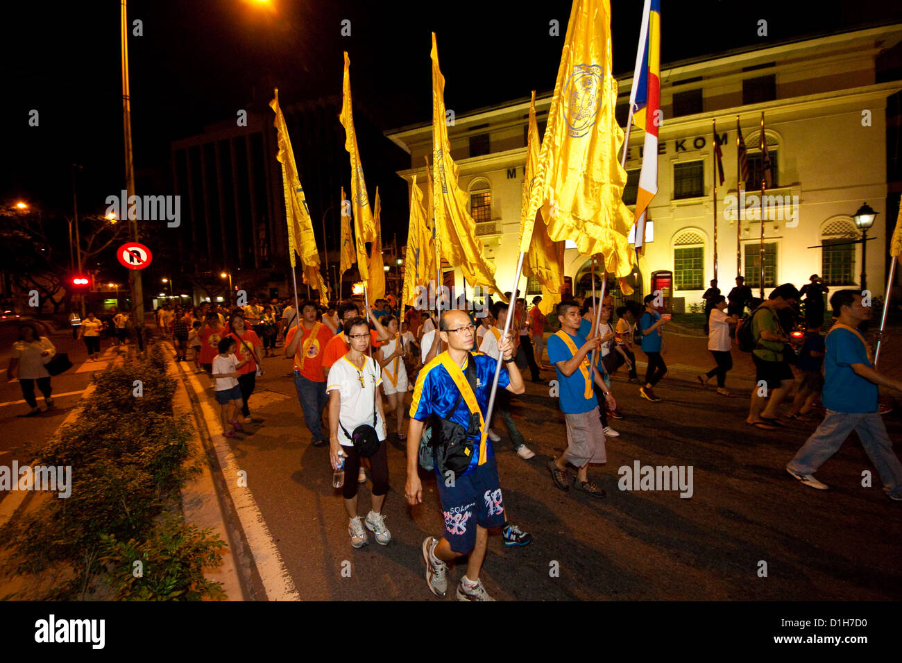 A group of devotees carry buddhish flags during Wesak Day procession on ...