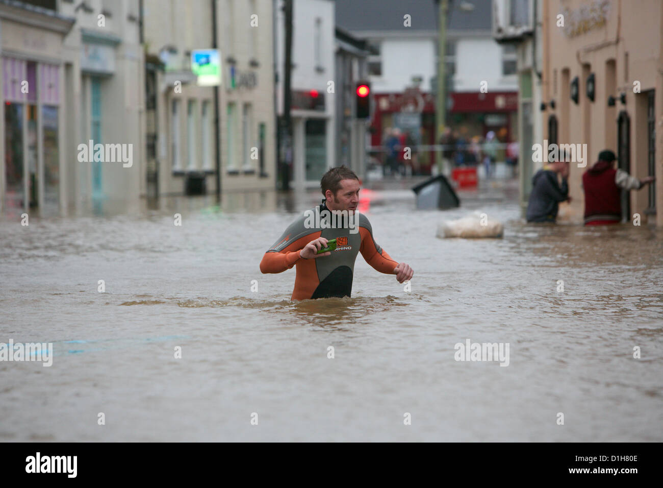 22/12/12 © Sam Friedrich A man in a wetsuit wades through floodwater in ...