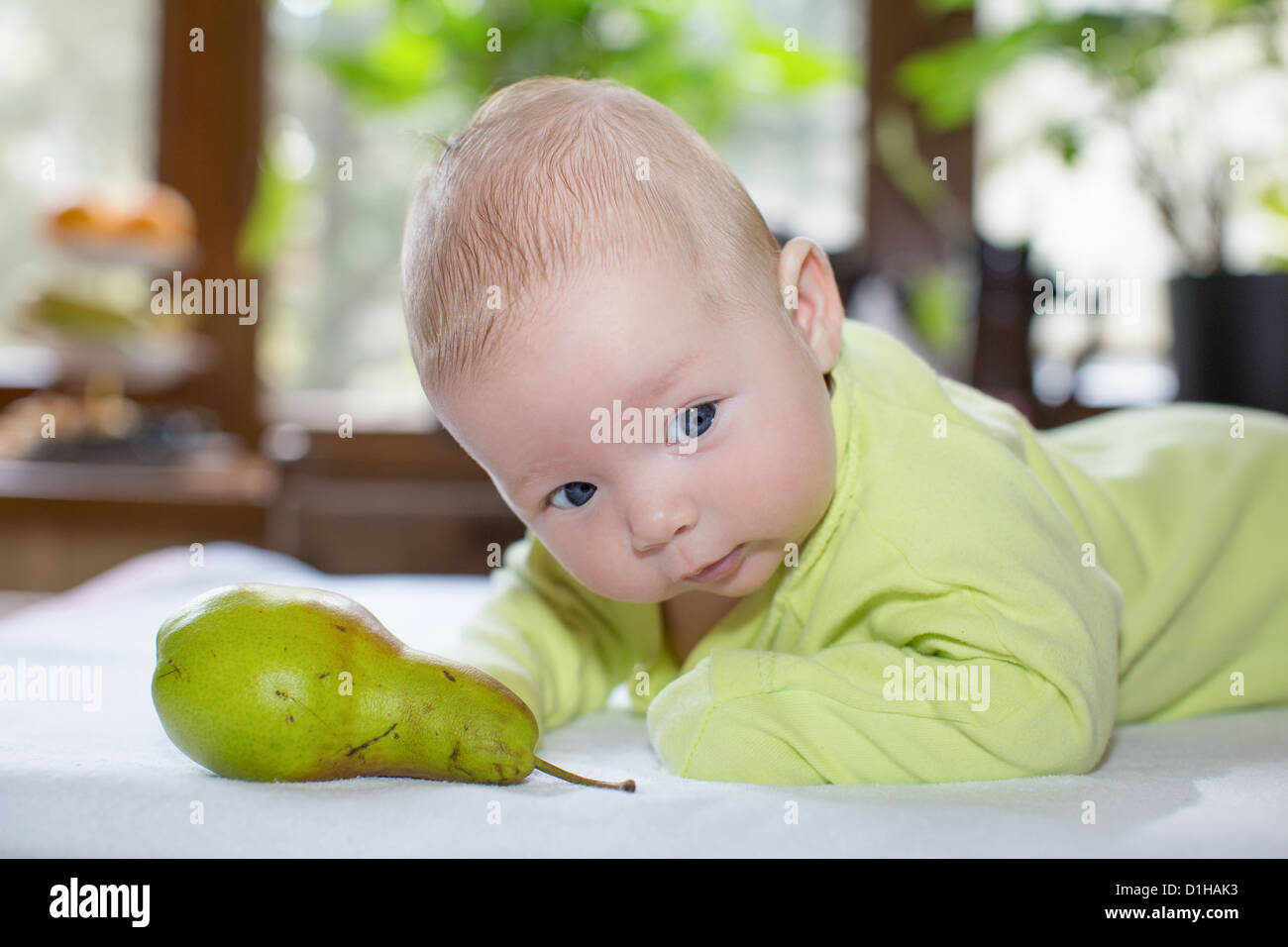 Newborn baby girl with a with fruit pear. The concept of food and ...
